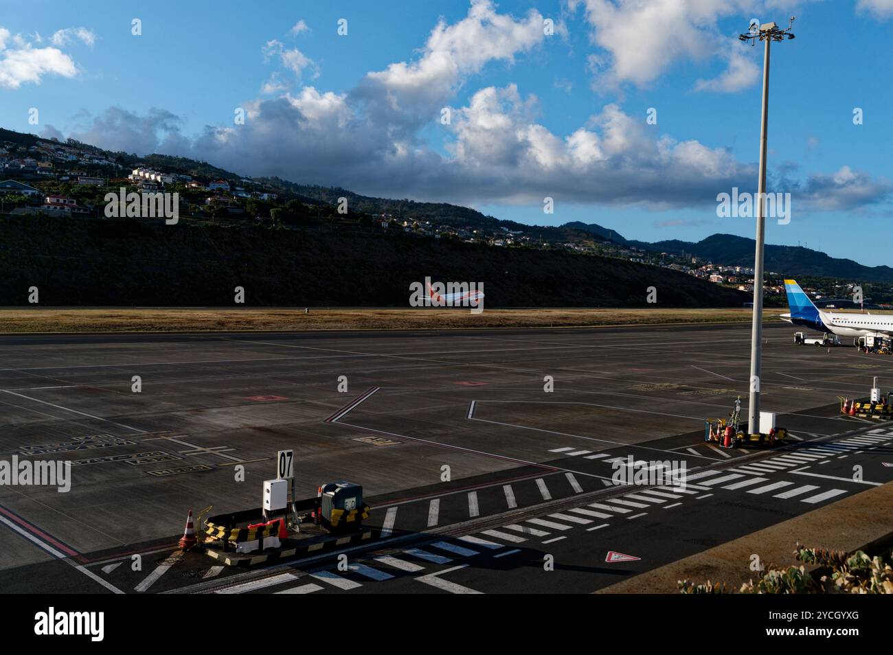 An aircraft accelerating on the runway at Funchal Airport, with the ...