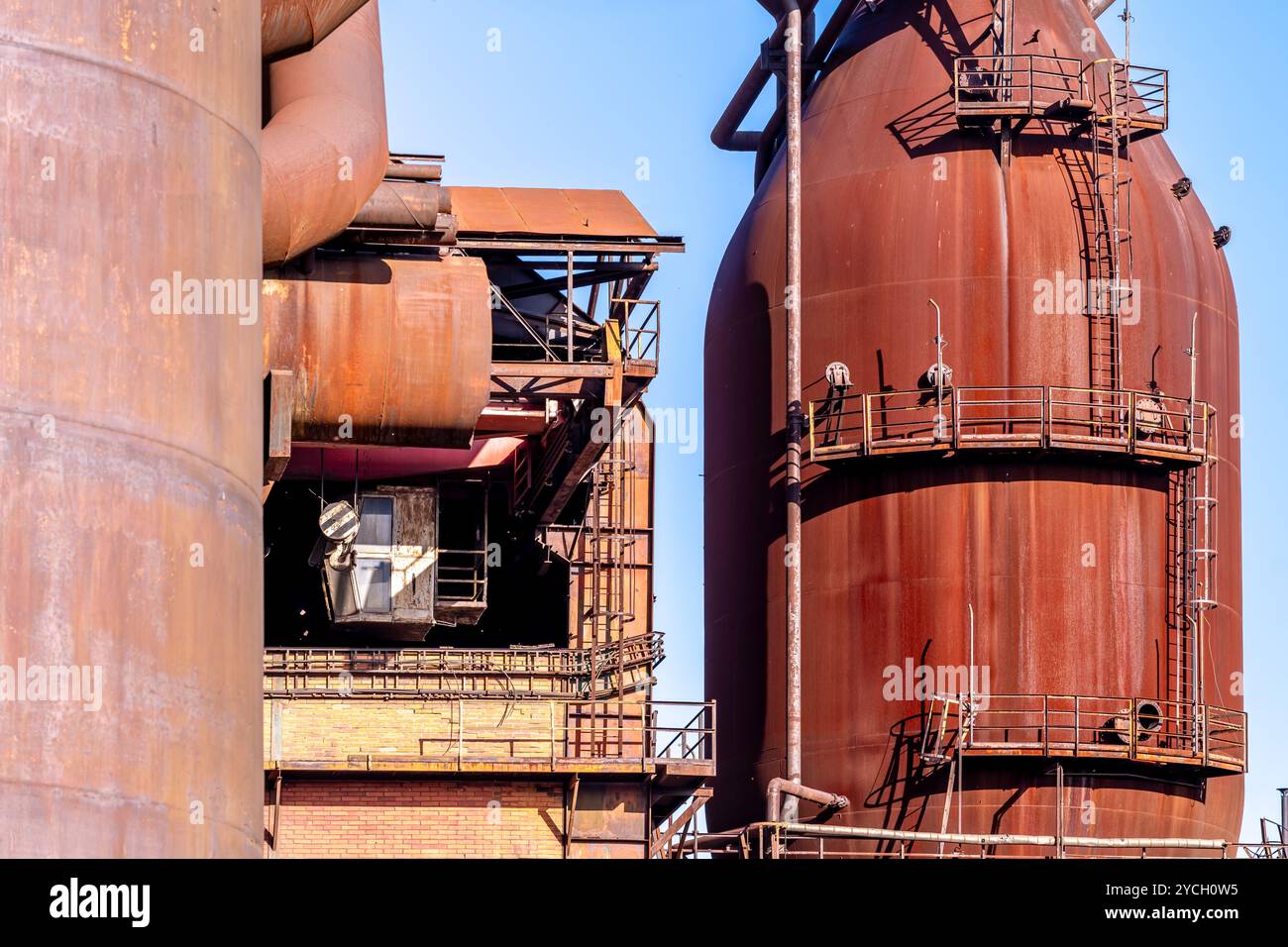 Old rusty industrial blast furnace standing tall over blue sky Stock ...