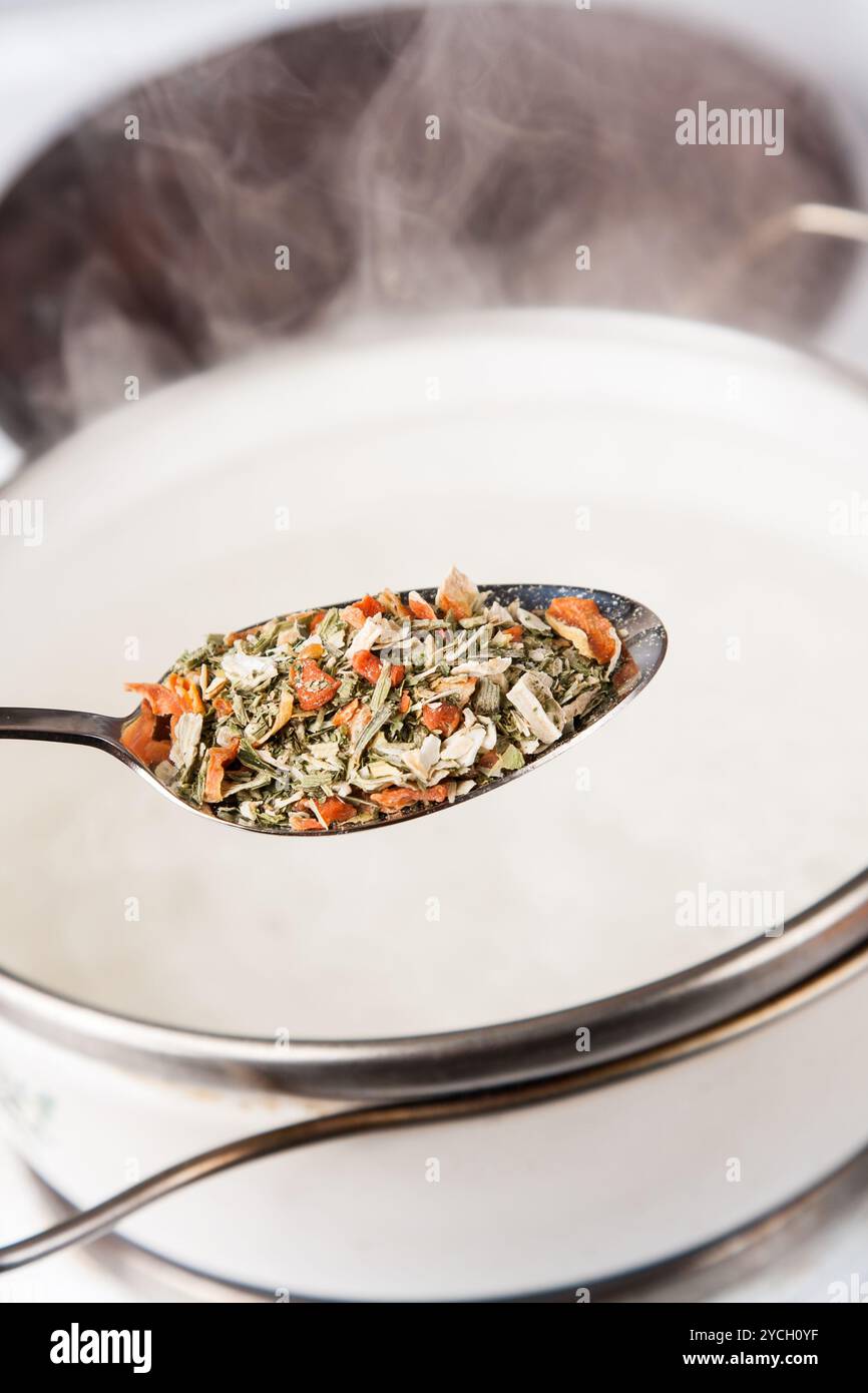 Seasoning in spoon for cooking in pot with steam Stock Photo - Alamy