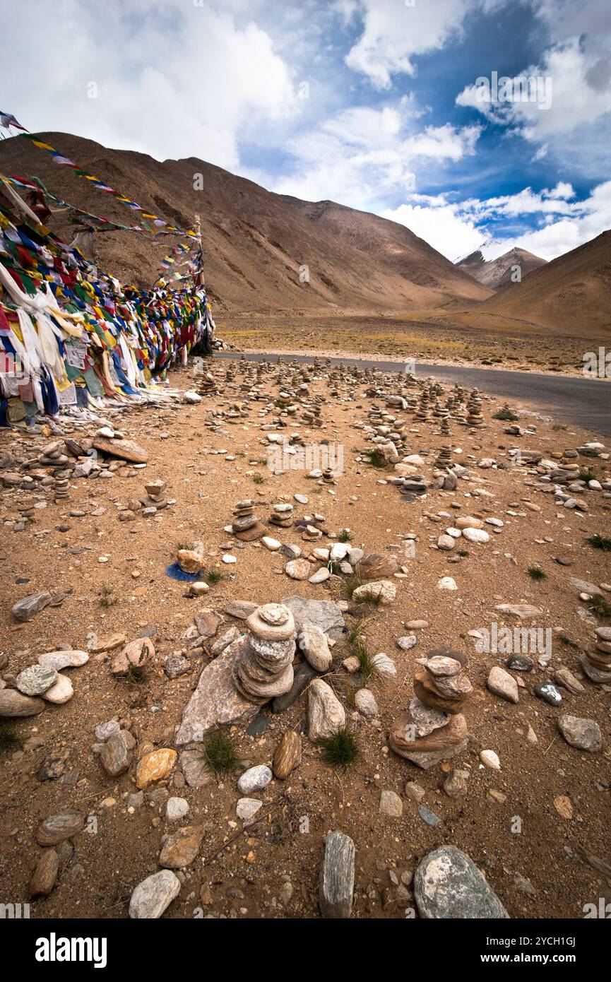 Highland road pass with stone pyramid and Buddhist praying flags. India ...