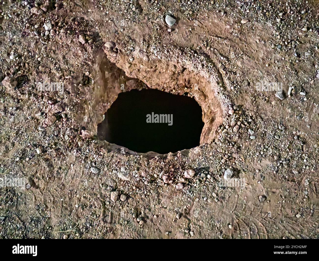 Watch Your Step: Black Hole on Illuminated Dirt Ground at Night Stock ...