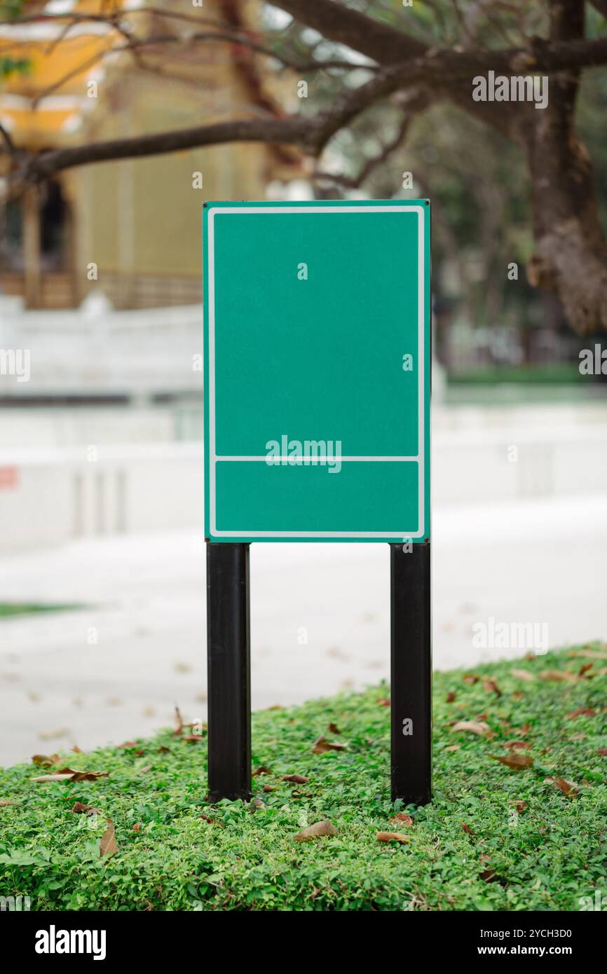 A blank green sign stands prominently in the park, awaiting information ...
