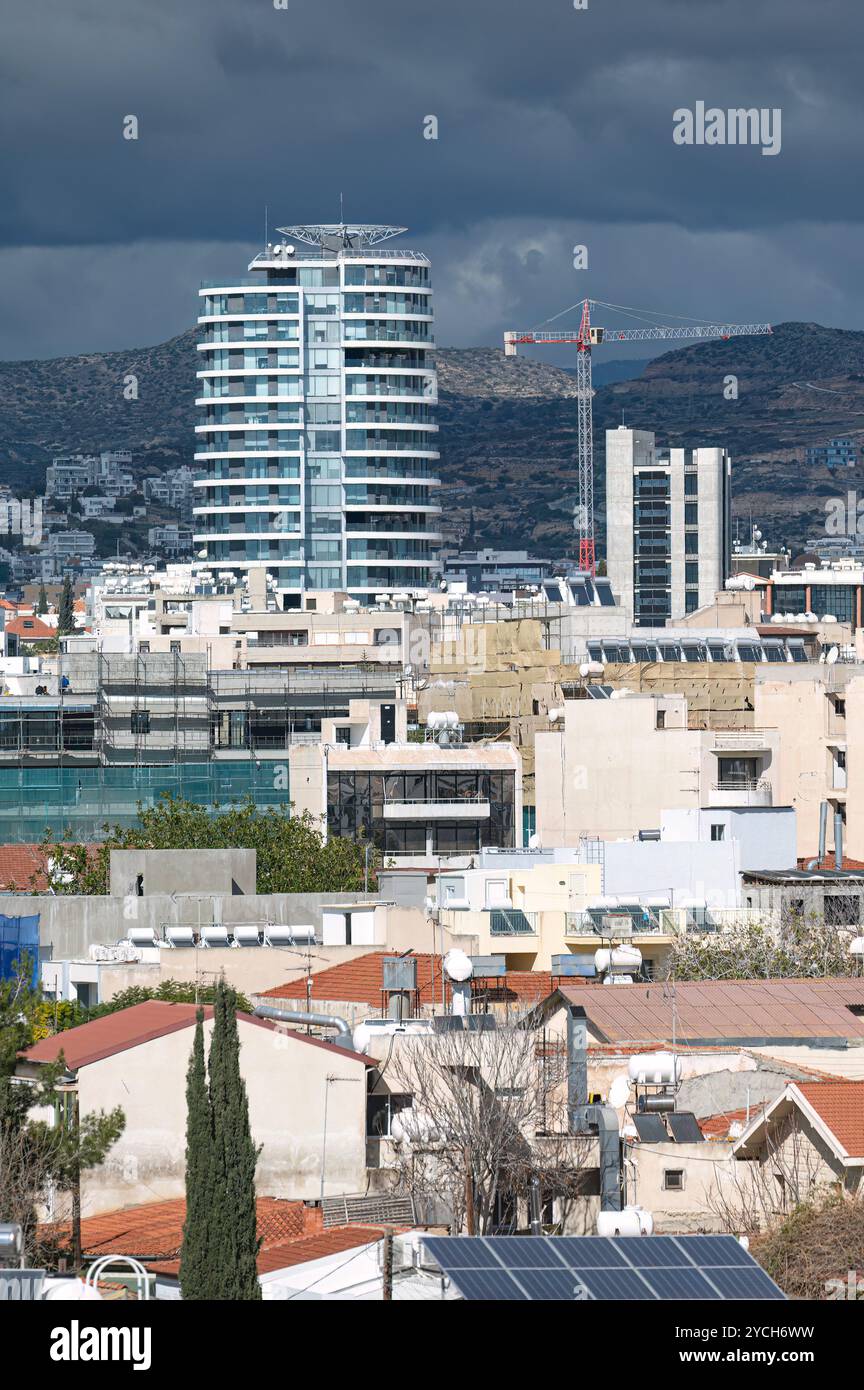 Modern skyscraper towering over traditional houses in Limassol Cyprus ...