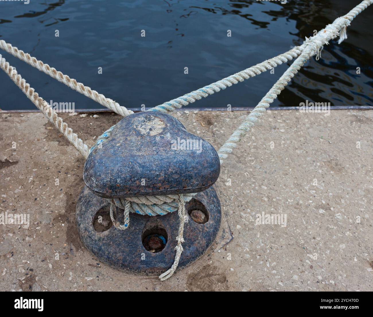 Mooring bollard with heavy rope Stock Photo - Alamy