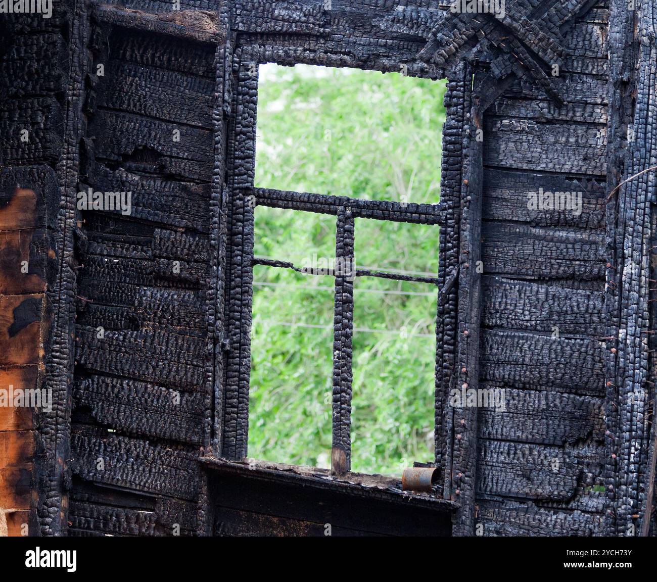 Burned wooden window frame with view to a green trees Stock Photo - Alamy