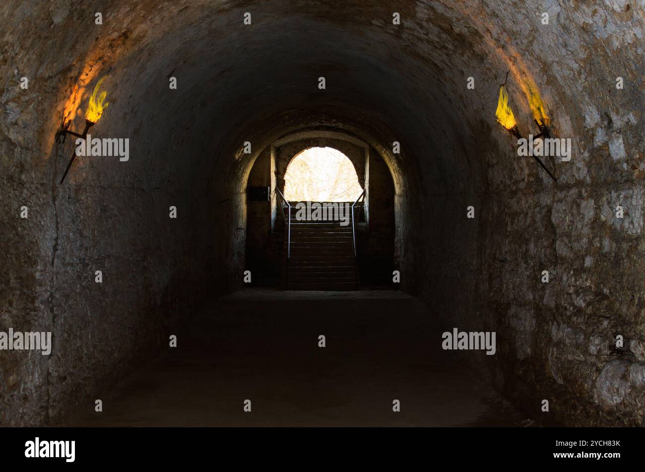 Catacombs of the old castle illuminated burning torches Stock Photo - Alamy