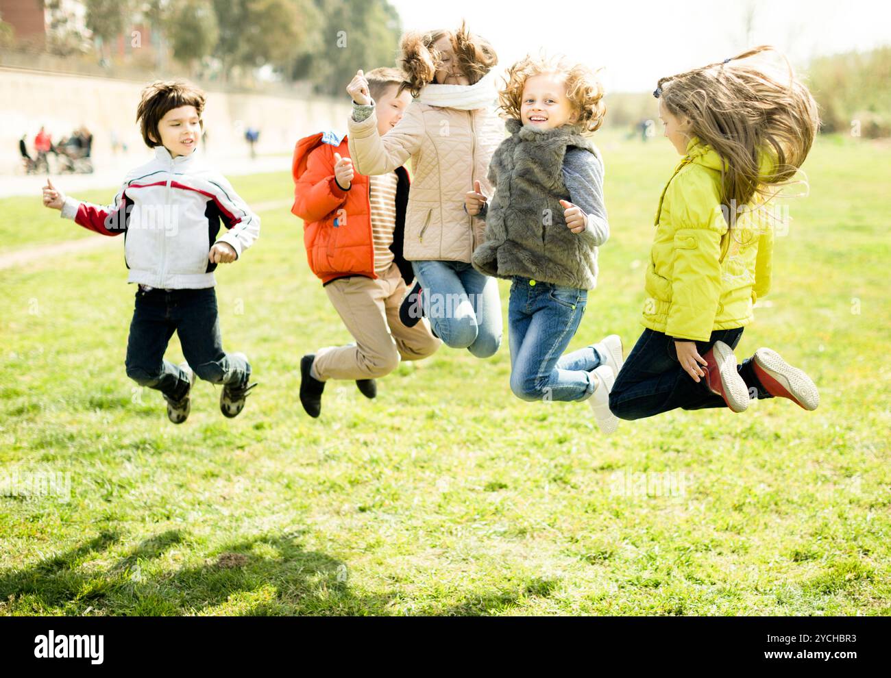 Children jumping on meadow hi-res stock photography and images - Alamy