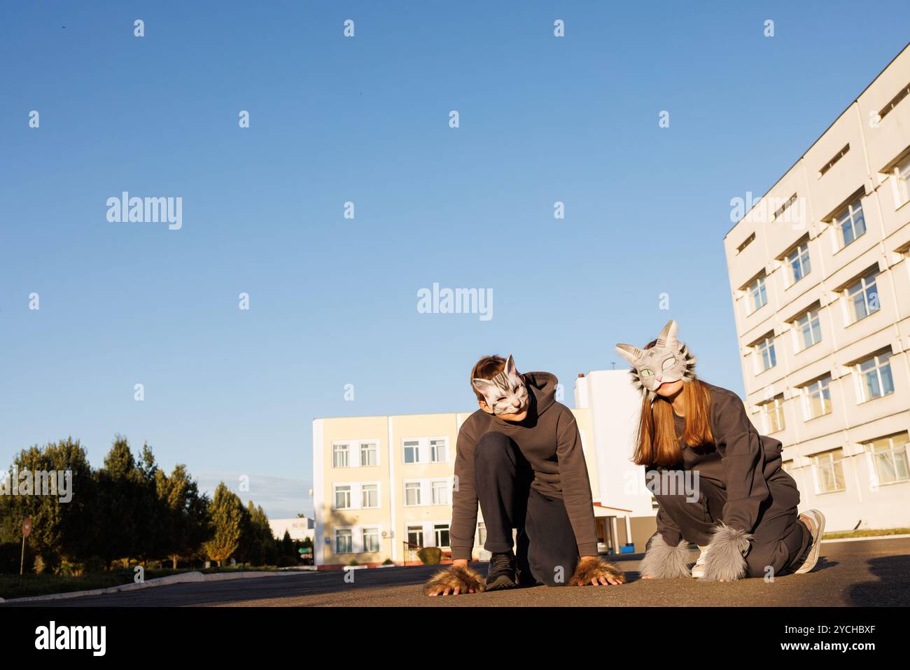 girl and boy in cat masks and cat costumes doing Quadrobics in the city ...