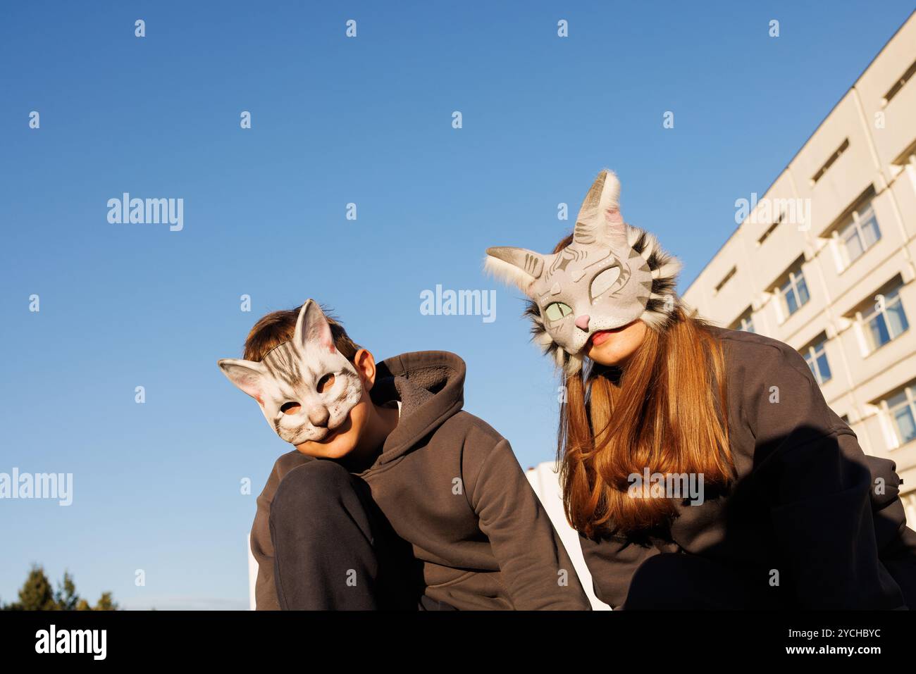 girl and boy in cat masks and cat costumes doing Quadrobics in the city ...