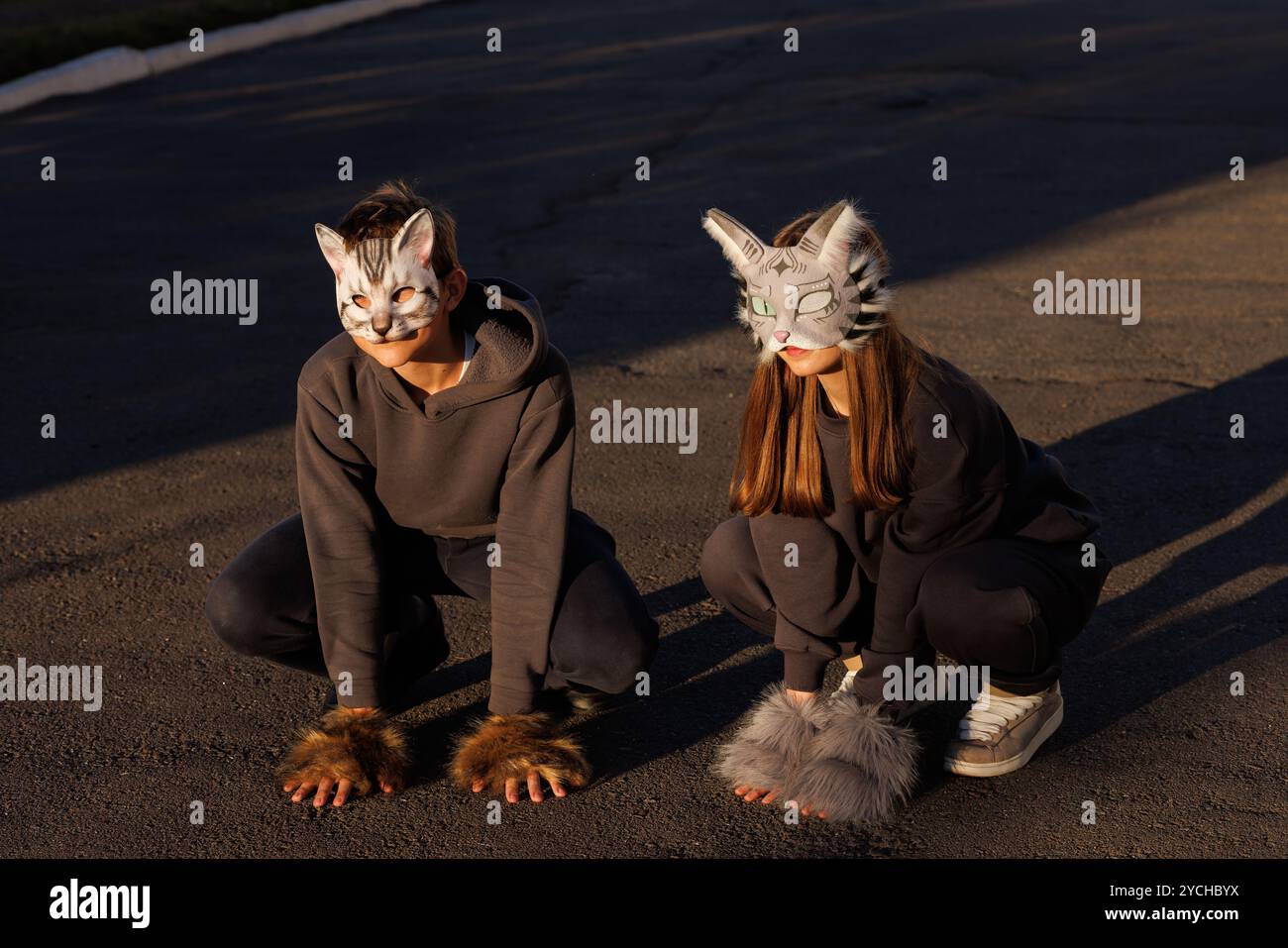 girl and boy in cat masks and cat costumes doing Quadrobics in the city ...