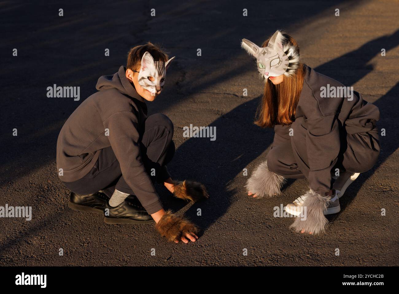 girl and boy in cat masks and cat costumes doing Quadrobics in the city ...