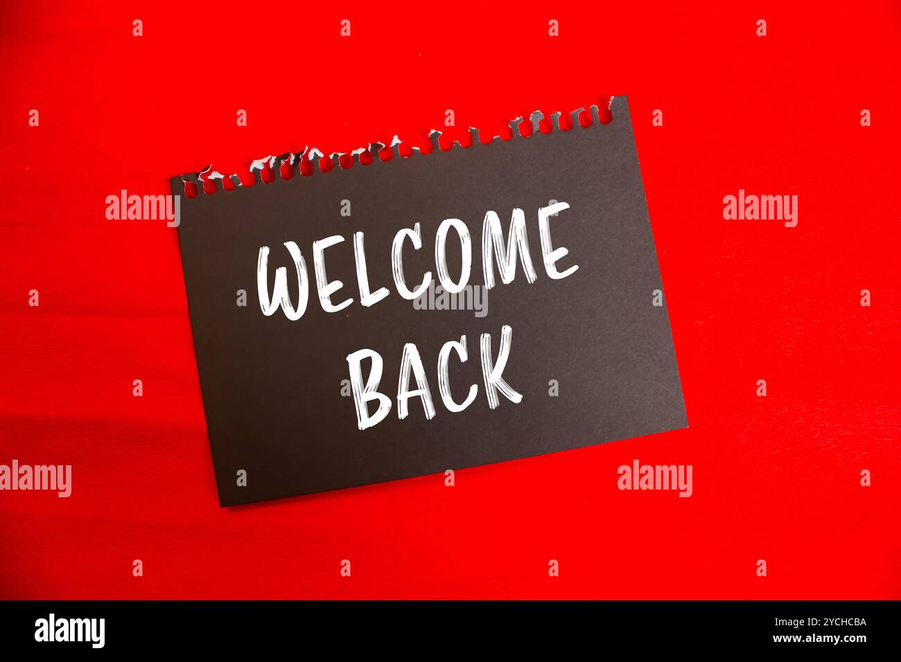 Welcome back message written on black notebook page paper with red ...