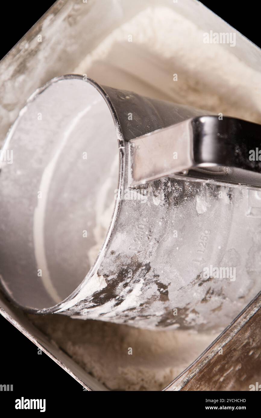 Measure cup with flour in box on black Stock Photo - Alamy
