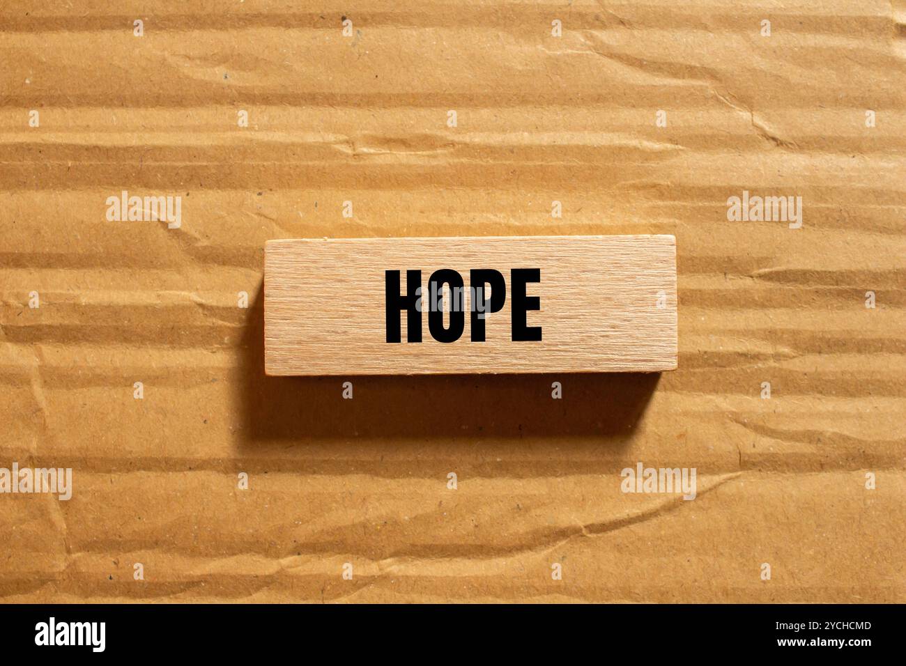 Hope message written on wooden block with cardboard background ...