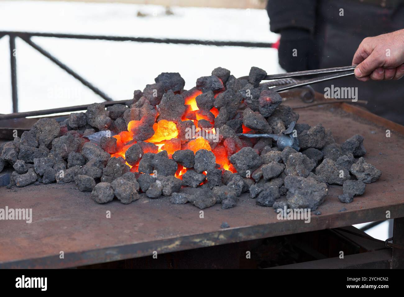 Craftsman blacksmith warming a piece of iron in the fire Stock Photo ...