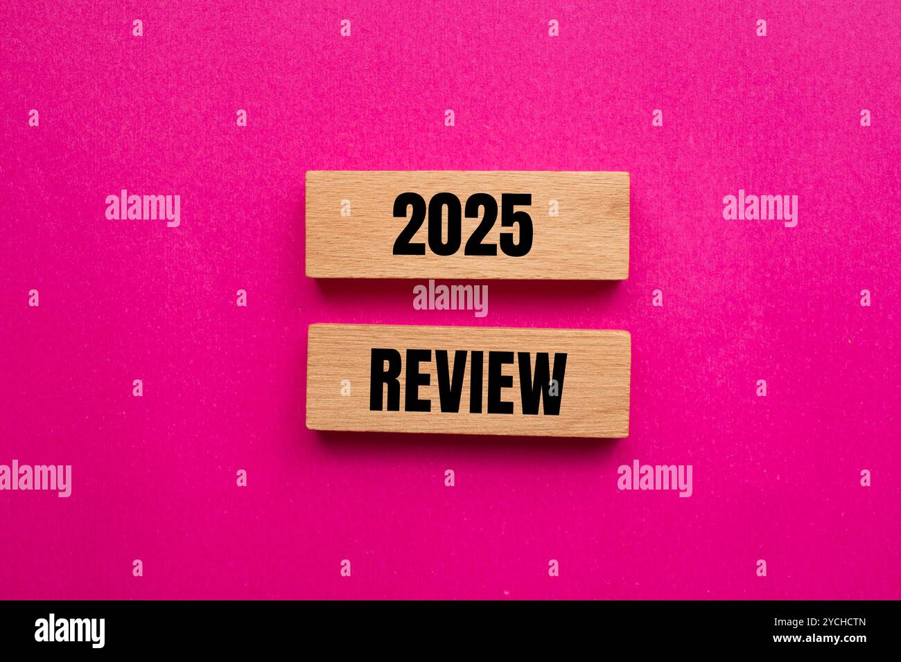 2025 review message written on wooden blocks with pink background. Conceptual 2025 review symbol ...