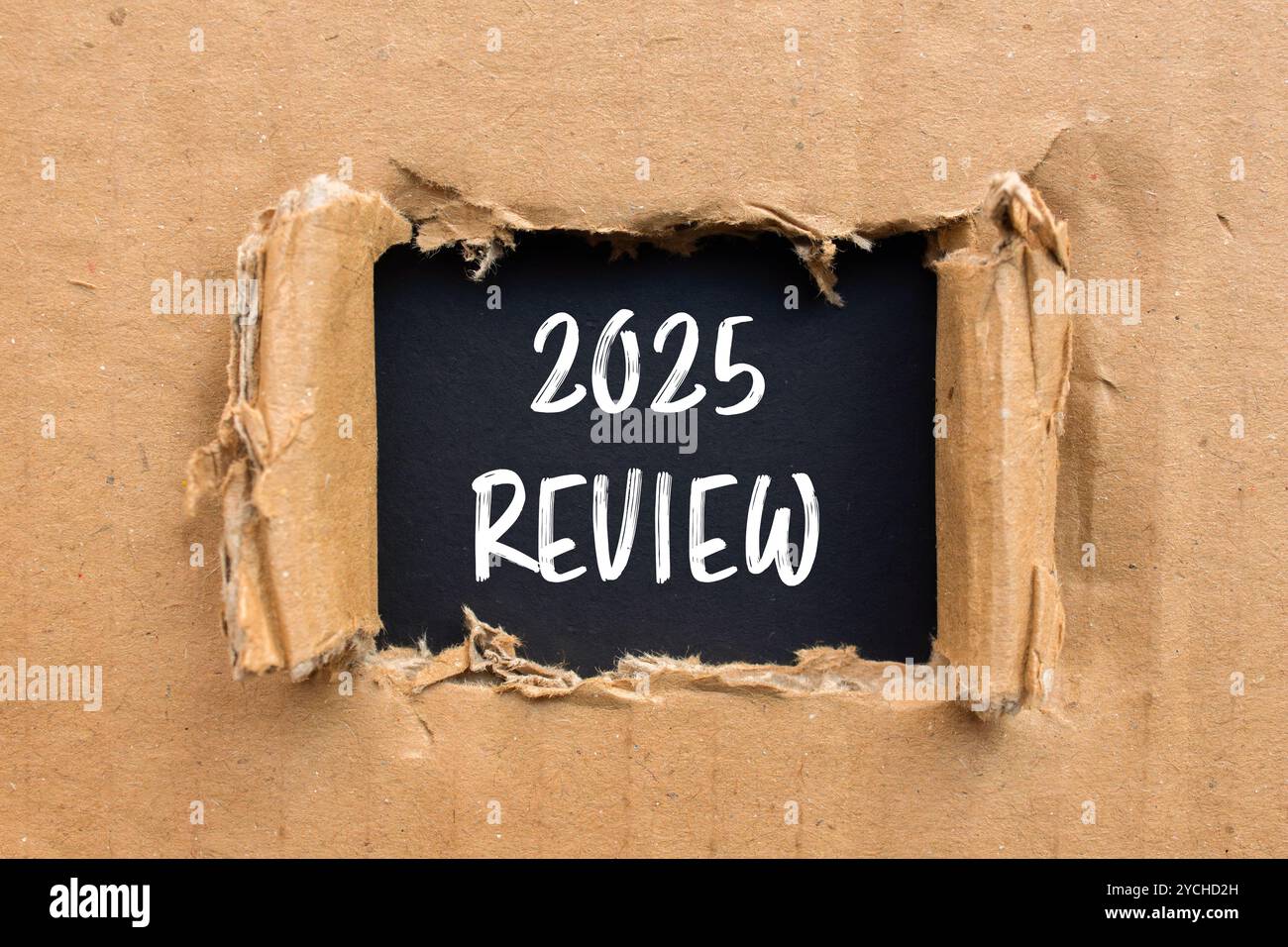 2025 review message written on ripped torn cardbaord paper with black ...