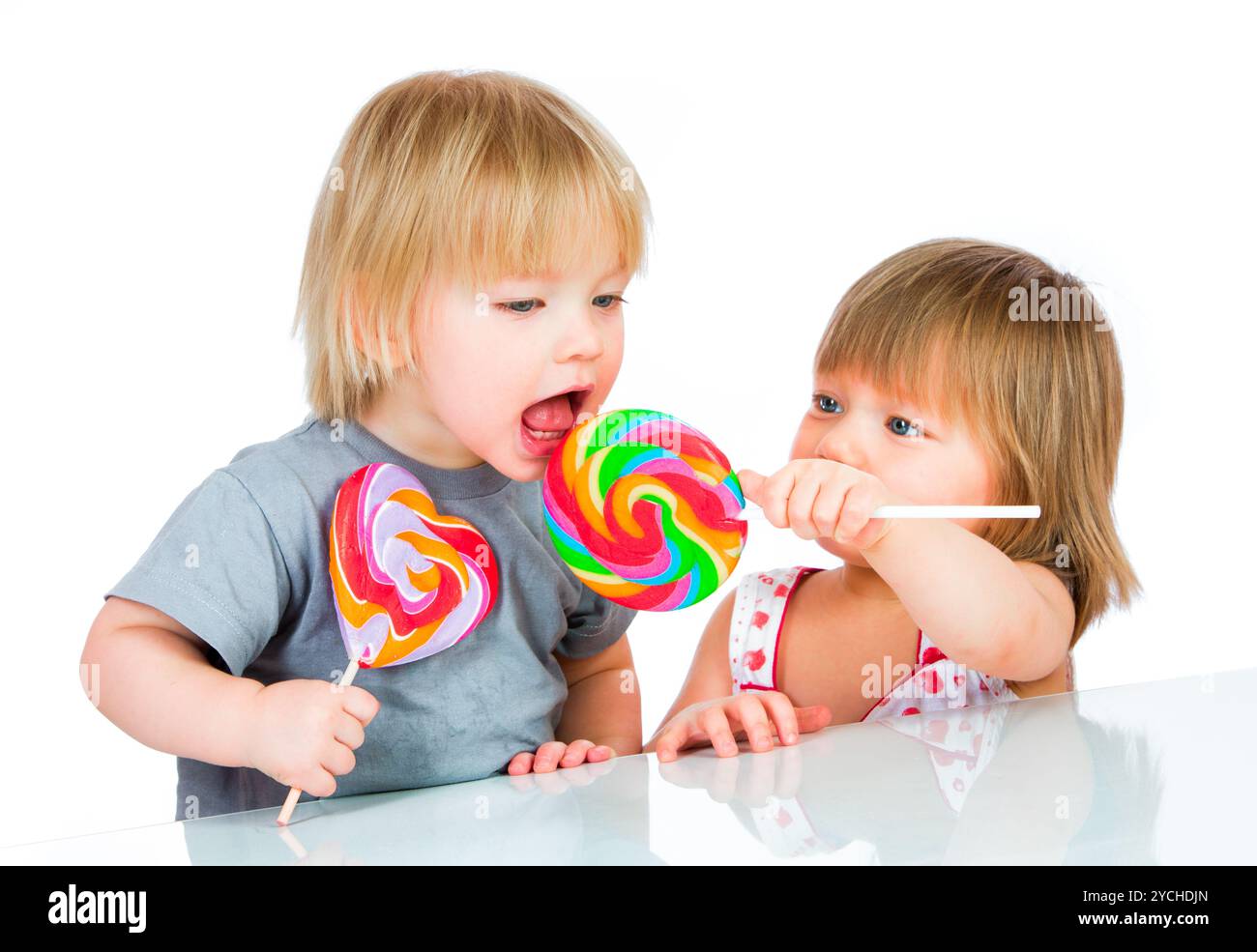 Babies eating a sticky lollipop on white background Stock Photo - Alamy