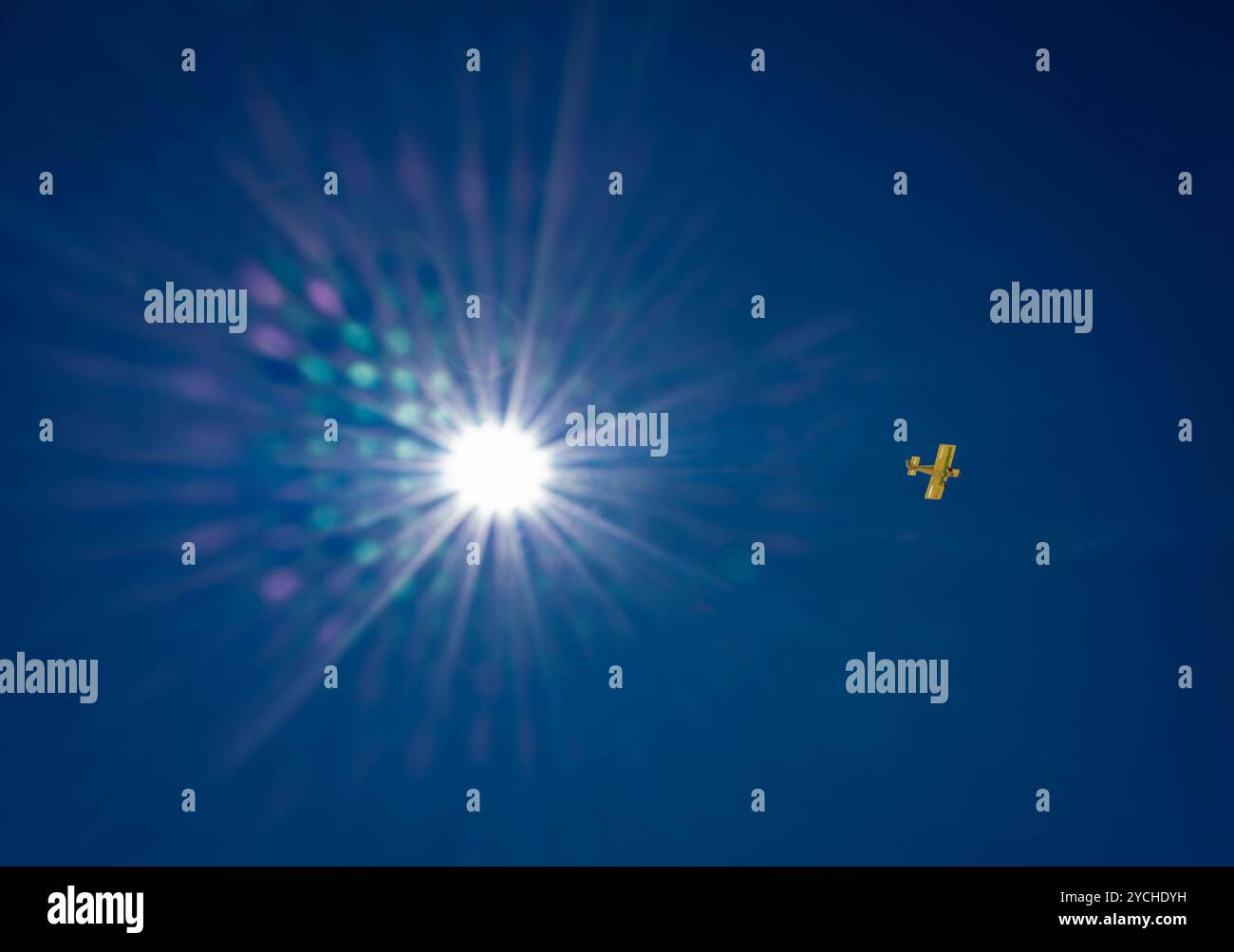 A yellow aircraft in a beautiful blue sky seen from the summit of Mont ...