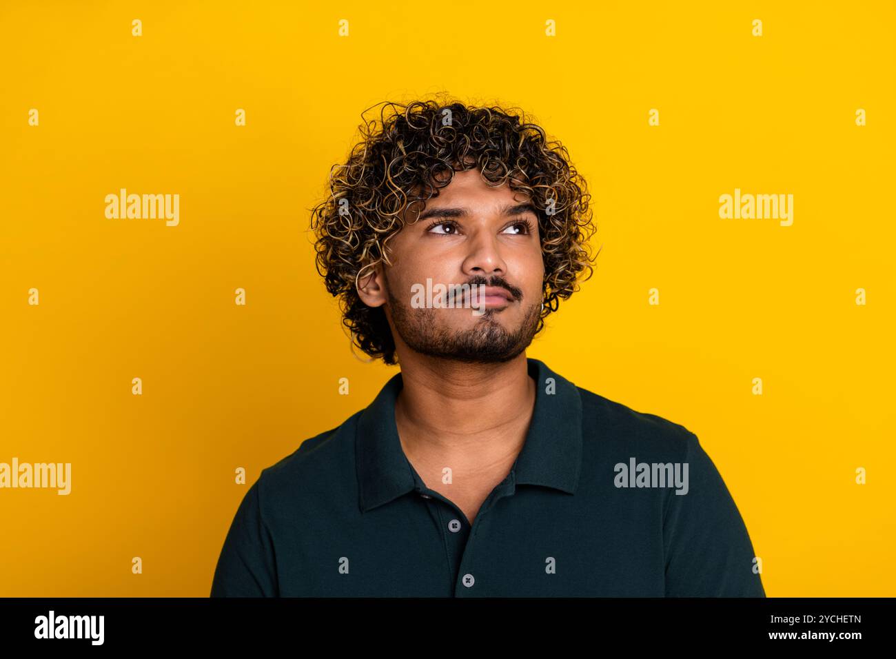 Young man pondering thoughts against bright yellow background wearing ...