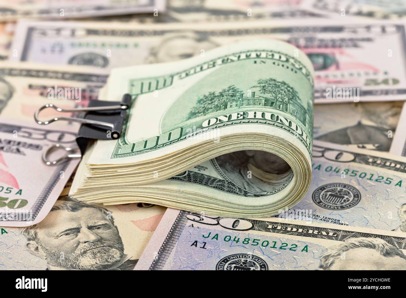 Folded hundred dollar bill on money background Stock Photo - Alamy