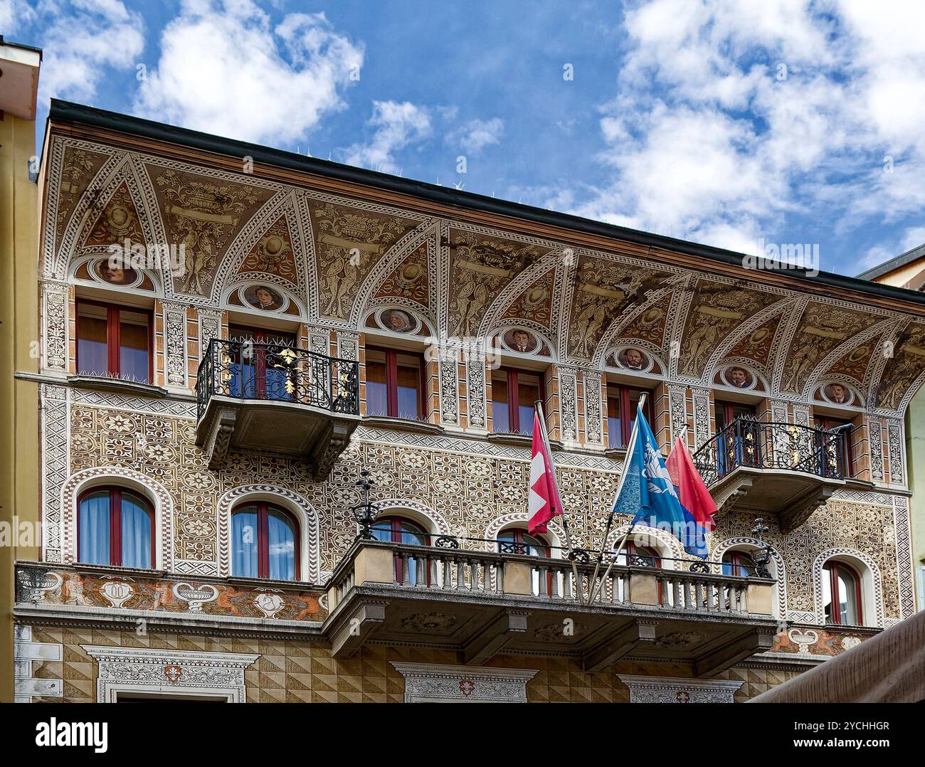 very decorative old building, balconies, curved facade, flags, ornate ...