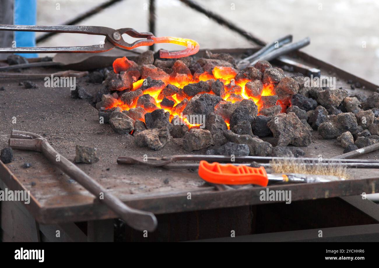 Craftsman blacksmith warming a horseshoe of iron in the fire Stock ...