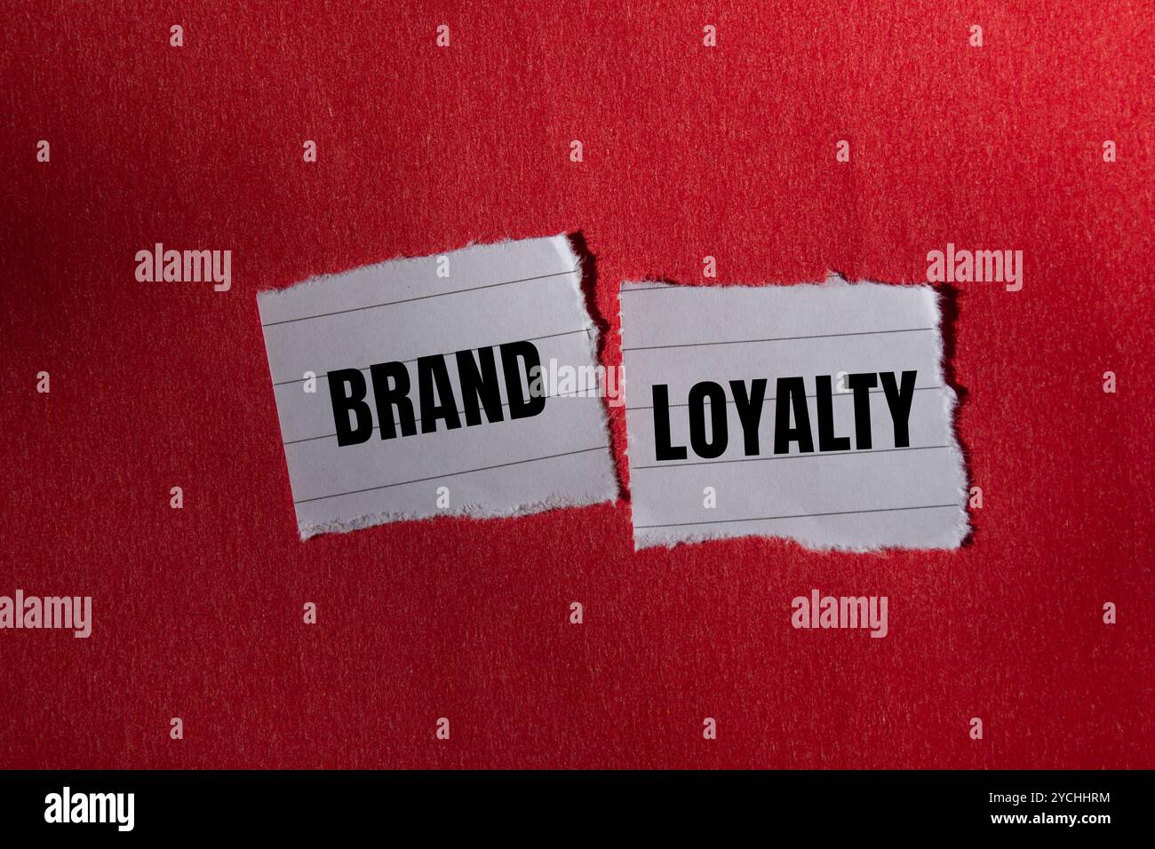 Brand loyalty message written on ripped torn paper piece with red ...