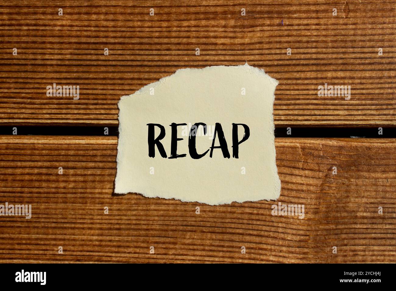 Recap message written on ripped torn paper with wooden background. Conceptual recap symbol. Copy ...