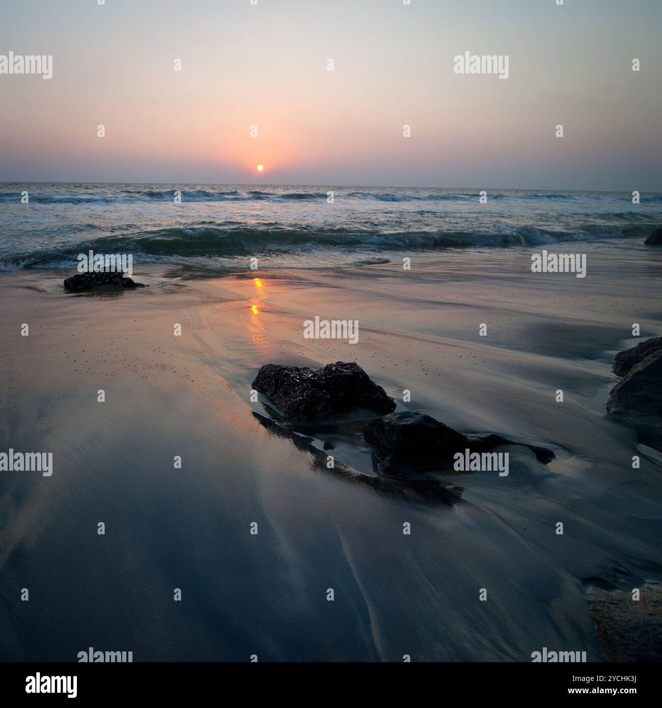 Sunset at tropical beach. Rocks at the ocean coast Stock Photo - Alamy