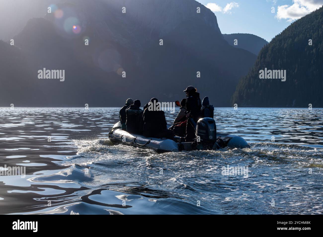 A group of eco tourists travel on an inflatable boat through the calm ...