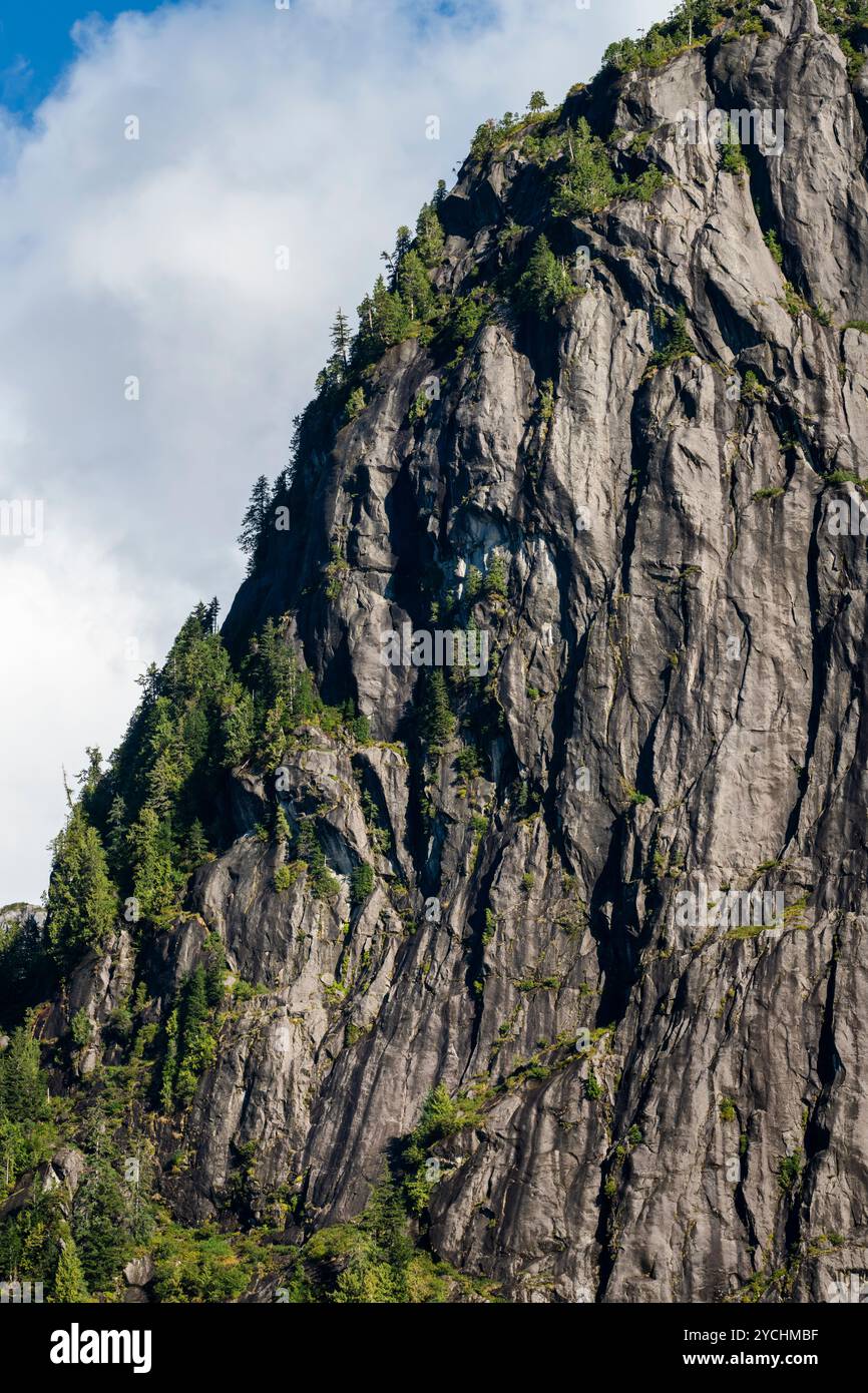 Vertical view of a steep rocky cliff face in the mountains of ...