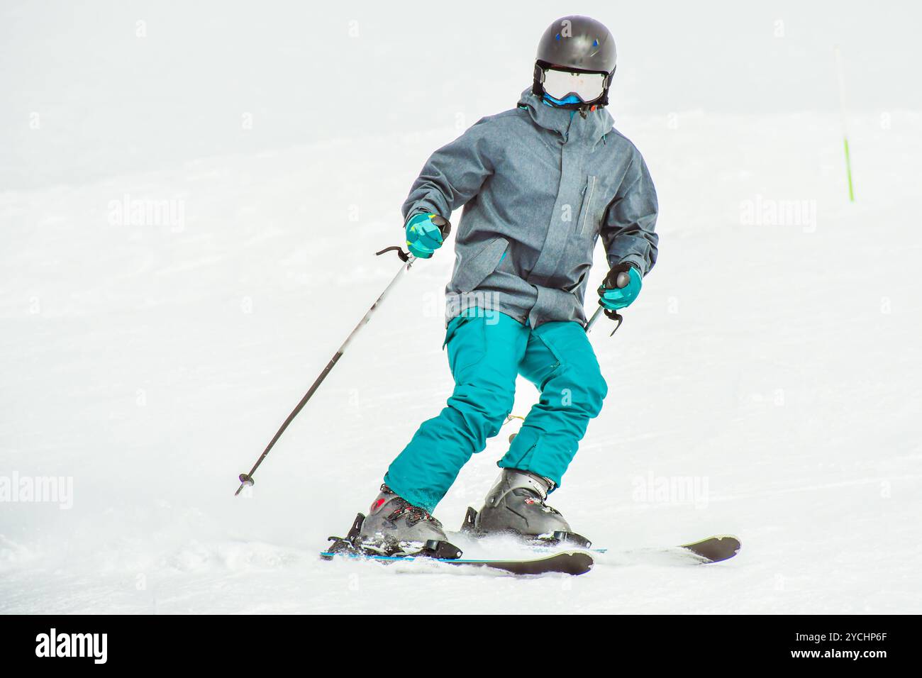 Young man learning to ski on a snowy slope close up front view isolated ...