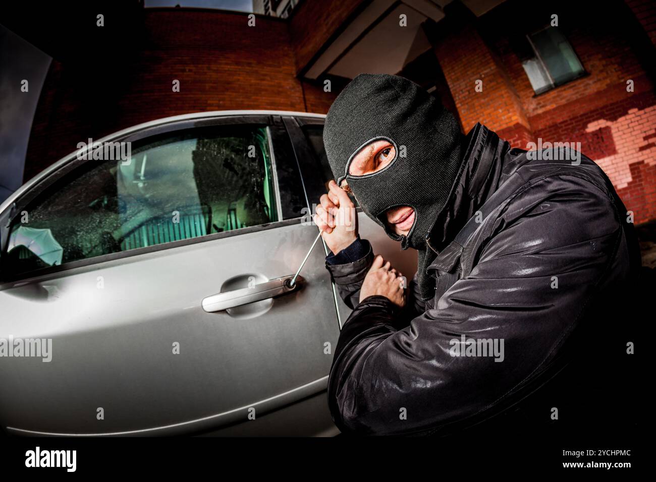 Car thief in a mask Stock Photo - Alamy