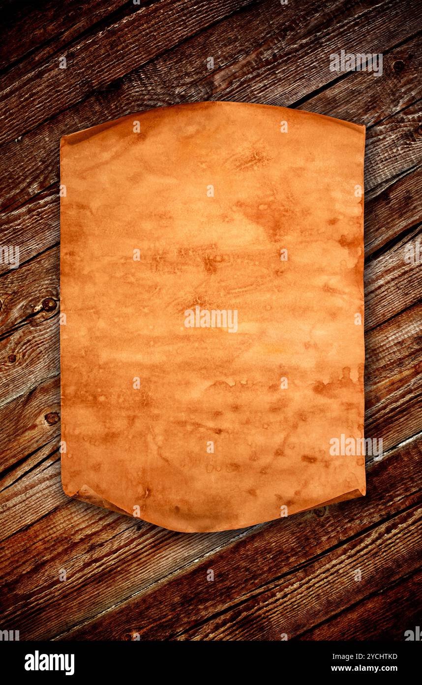 Blank old paper with curled edge against the background of an aged wood ...