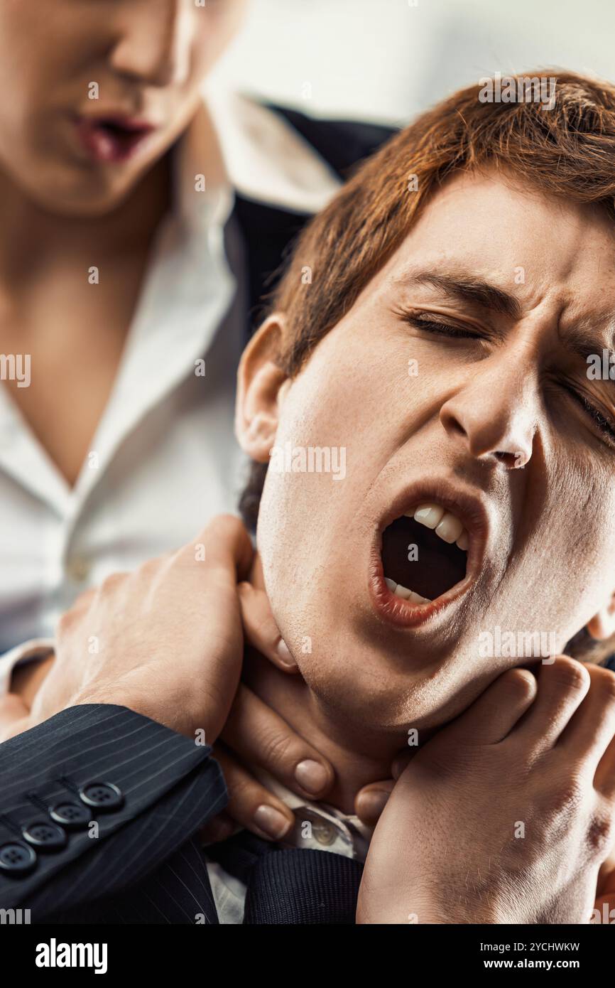 woman choking a male colleague, defying typical gender expectations of workplace violence. The ...