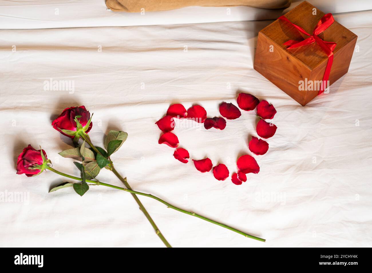 A romantic setup featuring two red roses and a heart shape made of rose ...