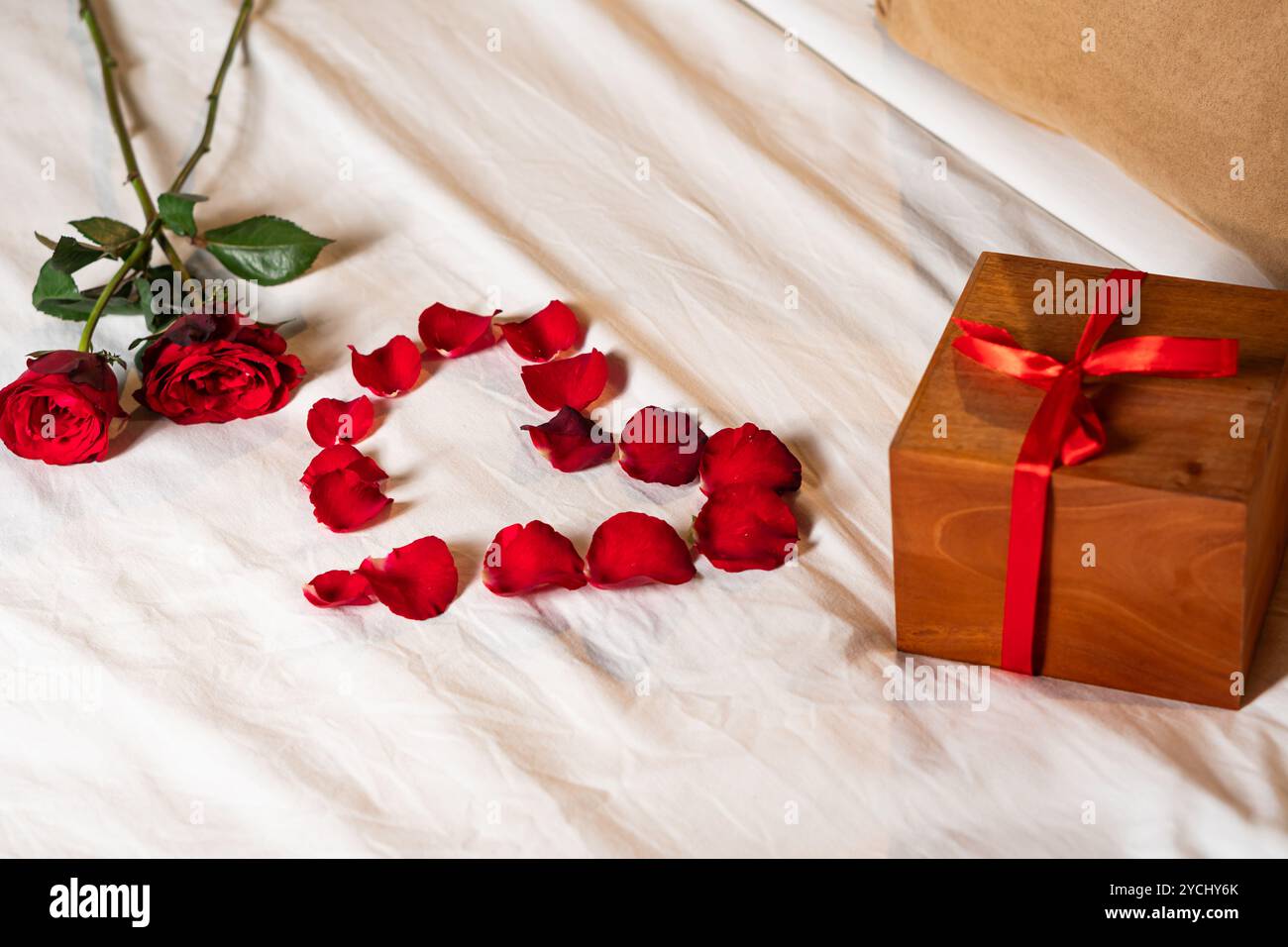 A romantic setup featuring two red roses and a heart shape made of rose ...