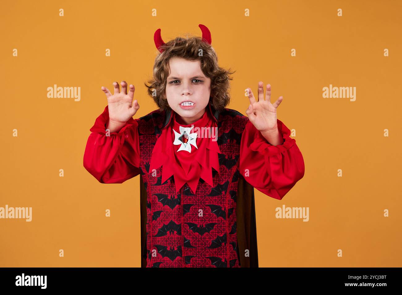 Little boy with fangs and scary facial expression standing in front of ...