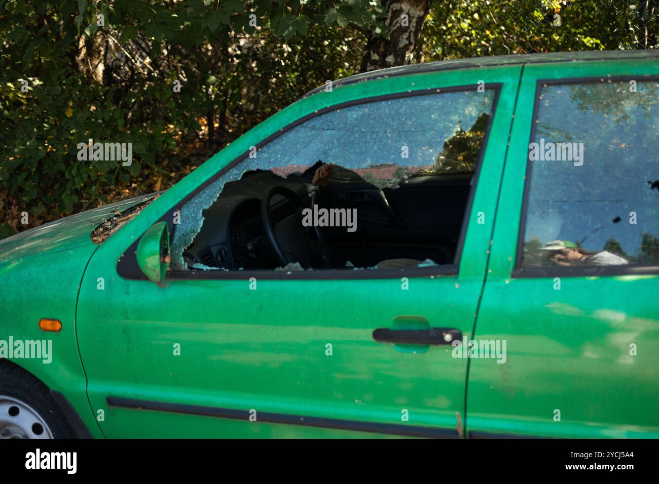 A criminal incident. Hacking the car. Broken left side window of a car ...