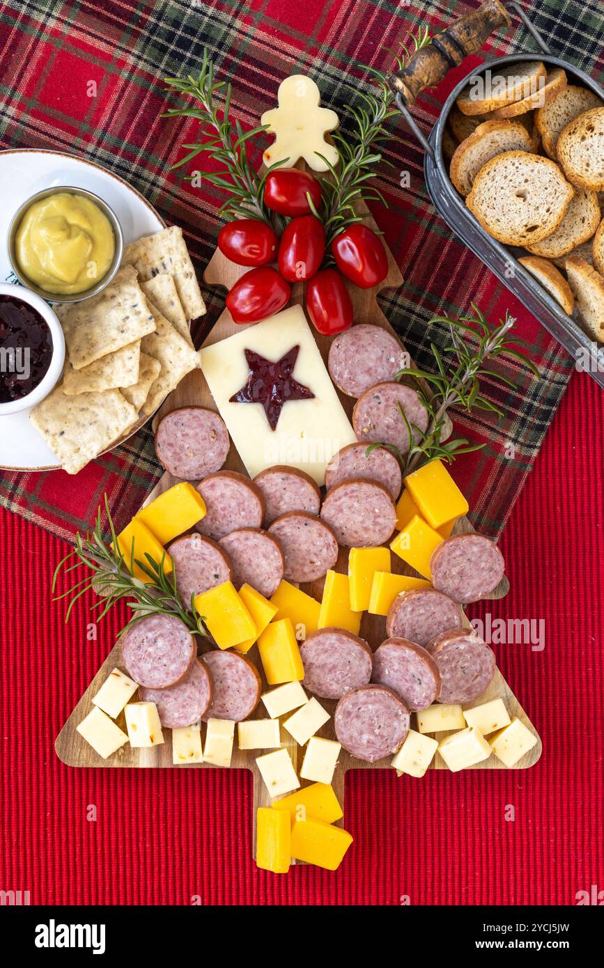 A pretty, festive charcuterie board on red napkins with cheese ...