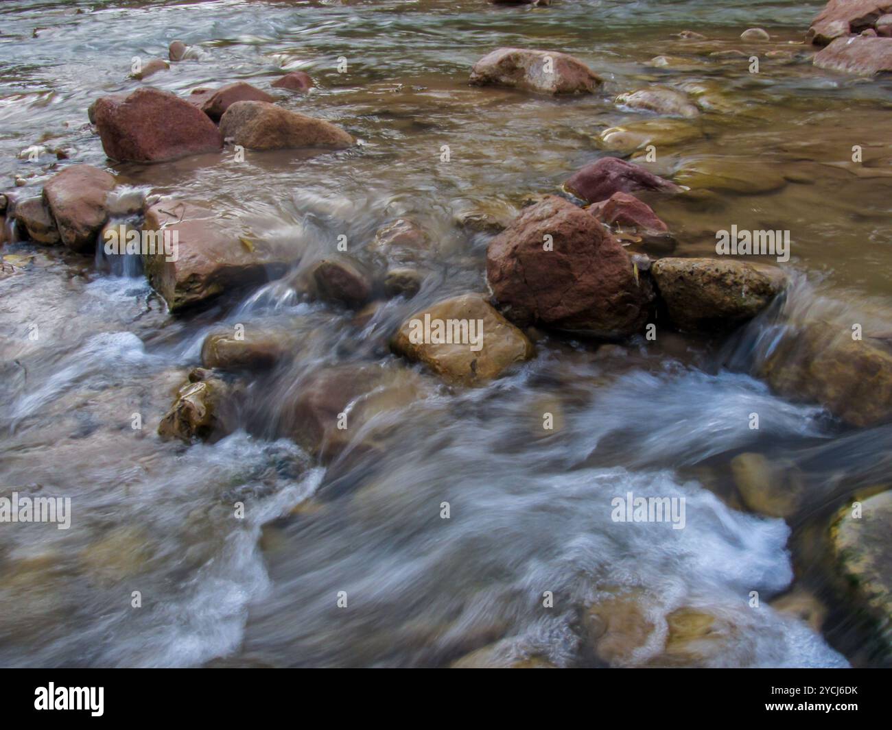 Fast flowing water over the rocks in the riverbed of the Virgin River ...