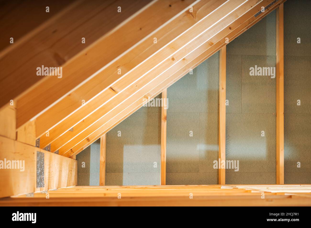 Light streams into an unfinished attic showcasing wooden rafters and ...