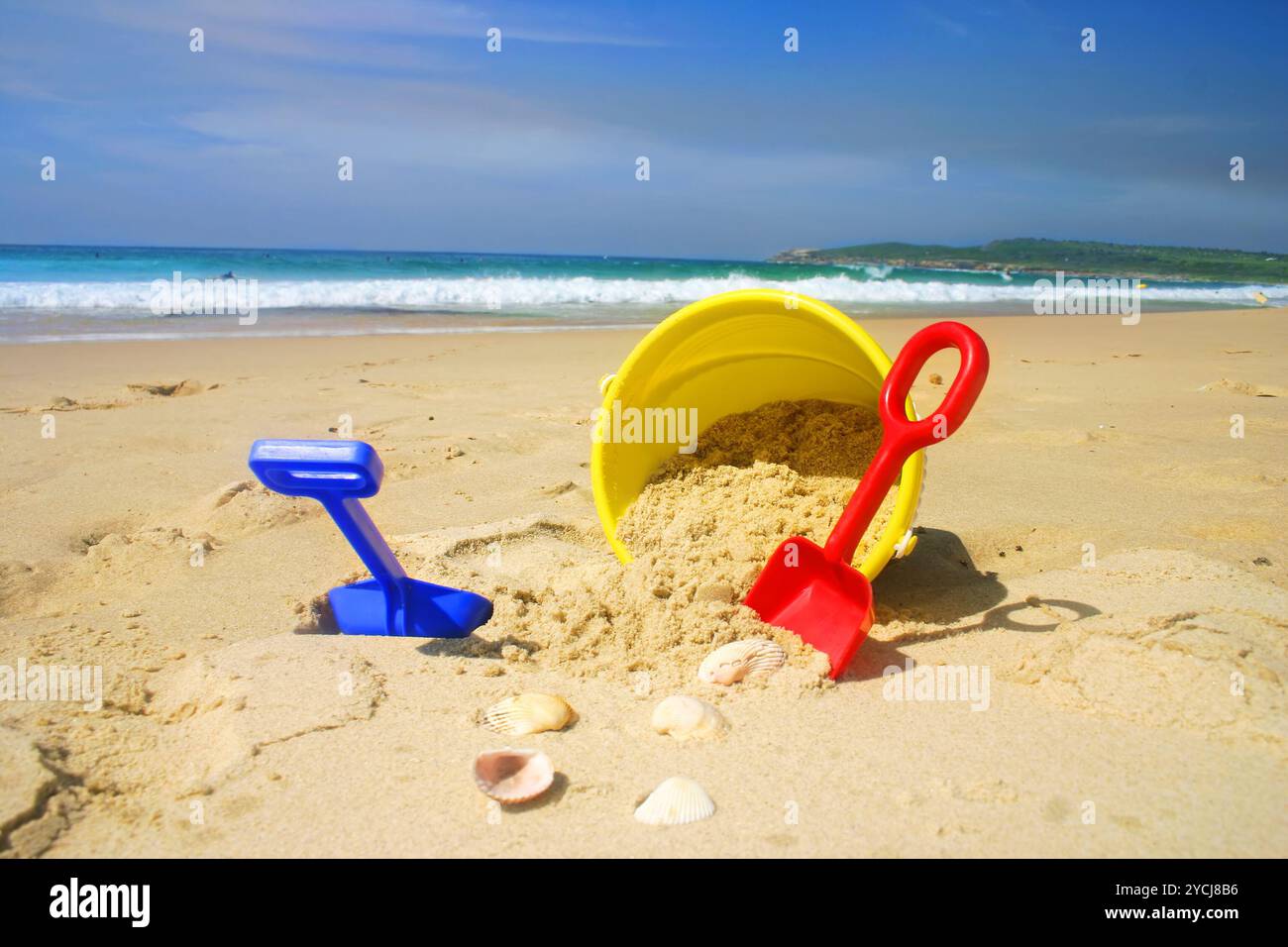 Child's beach bucket and spade on a sandy beach with seashells Stock ...