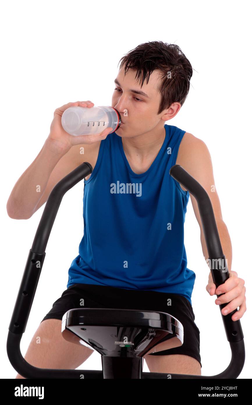 Teenager using exercise bike fitness gym Stock Photo - Alamy