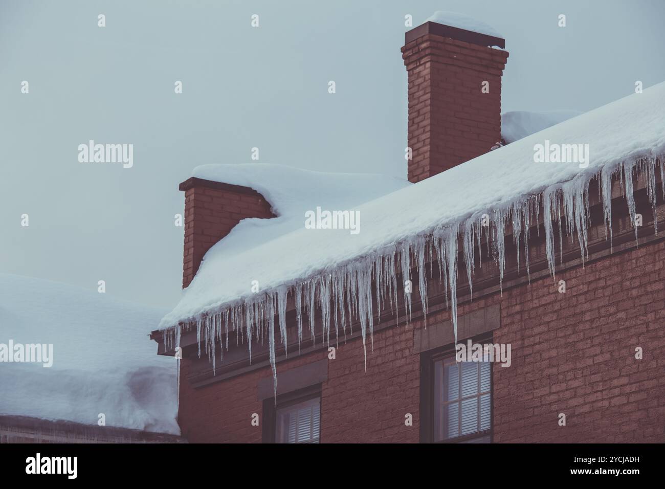 Icicles on Roof of Brick Building with Two Chimneys Stock Photo - Alamy