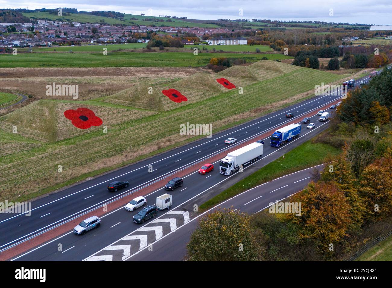 Giant poppies painted onto the grass pyramids alongside the M8 motorway ...