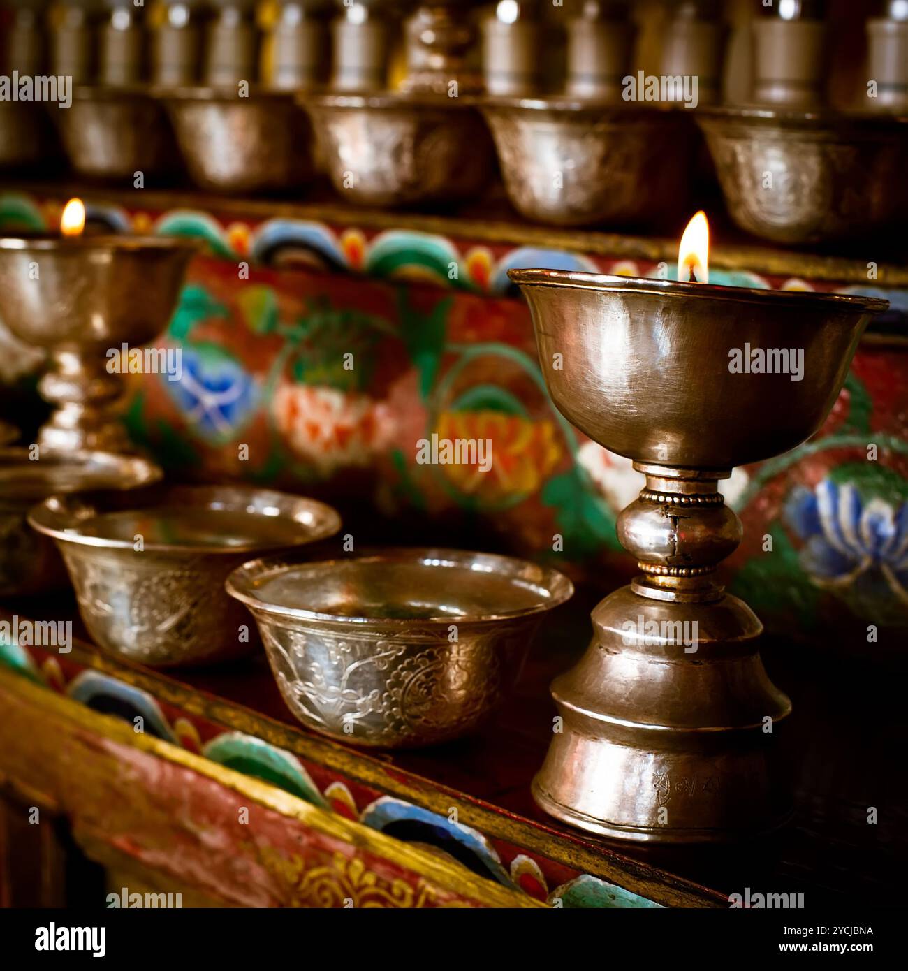 Burning oil lamps and offering bowls at Buddhist monastery temple ...