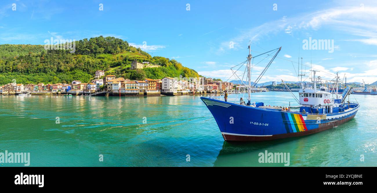 A fishing boat crossing the Pasajes Bay, in front of the fishing ...
