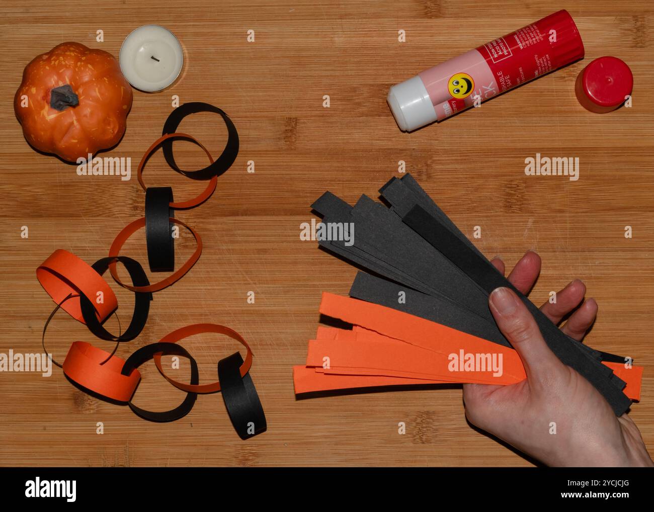 Preparing a diy halloween decorative chain, making black and orange ...